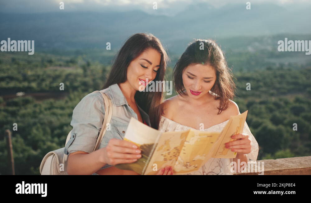 Two travlelling friend girls exploring the map of Greece. Travel ...