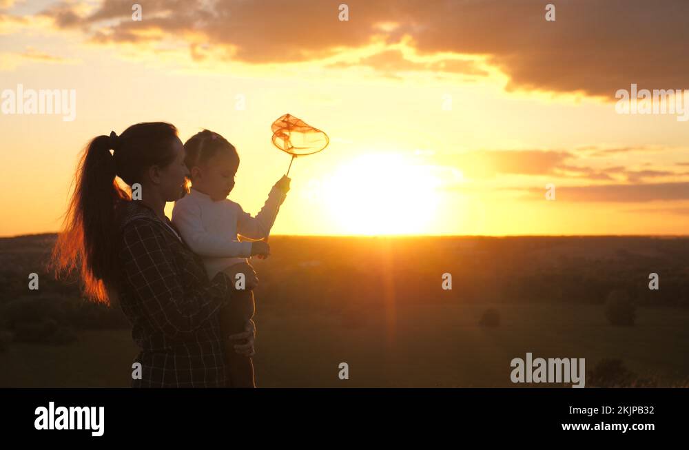 Mom and daughter play catching the sun, playing with rays. concept of a ...