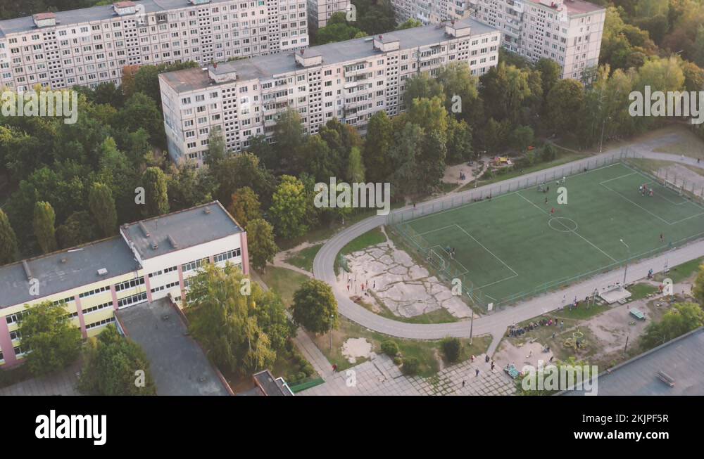 School stadium and Soviet era school building among apartment buildings ...