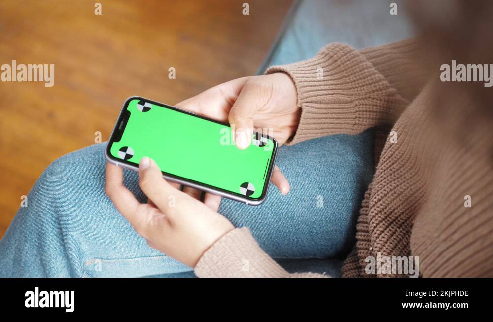 исание: Woman holding mobile phone with green screen chroma key and ...