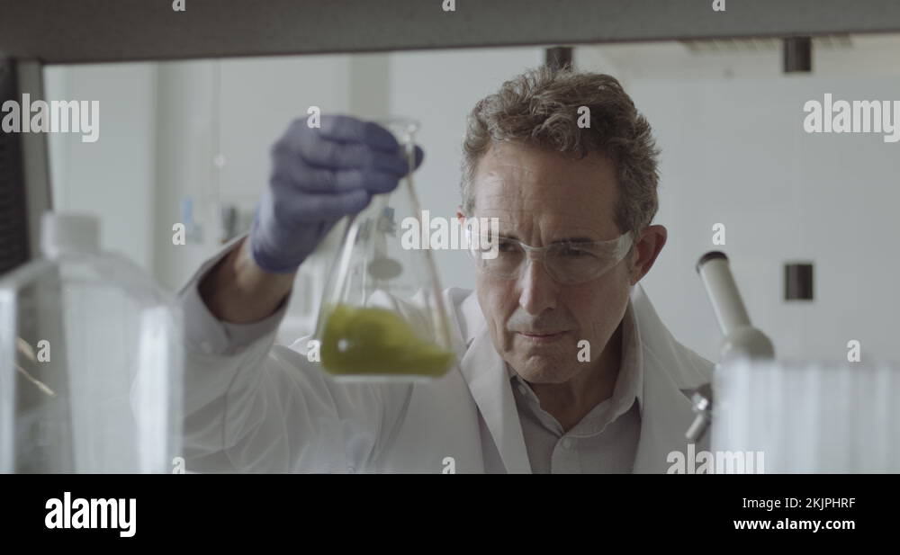 Mature male Laboratory Scientist Conducts Experiment in Science lab ...