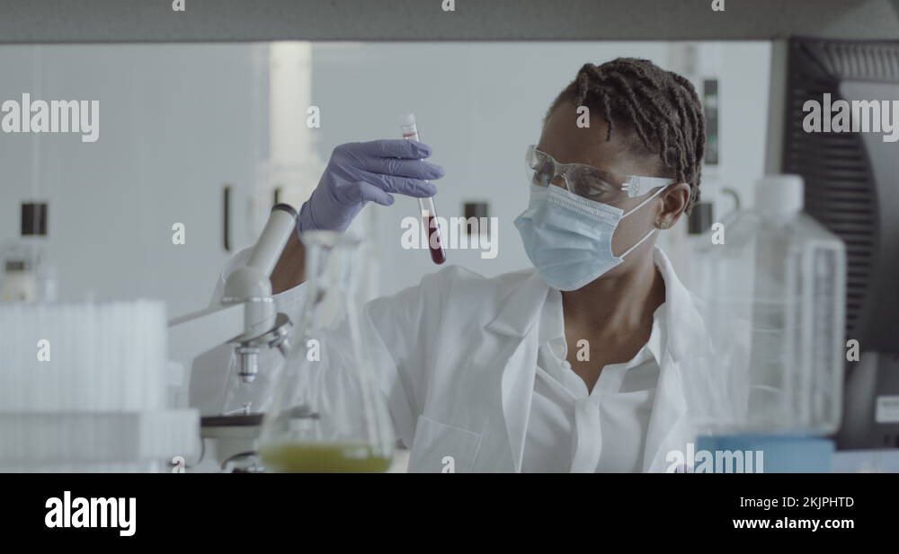 Female Laboratory Scientist Conducts Experiment in Science lab looking ...