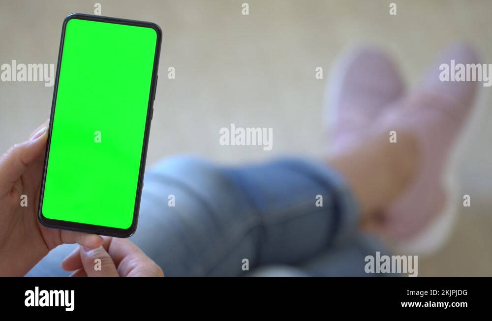 Handheld Camera: Back view of brunette holding chroma key green screen ...