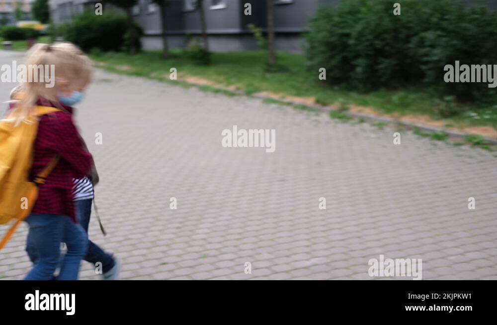 4k back to school. children playing on street, spinning with backpacks ...