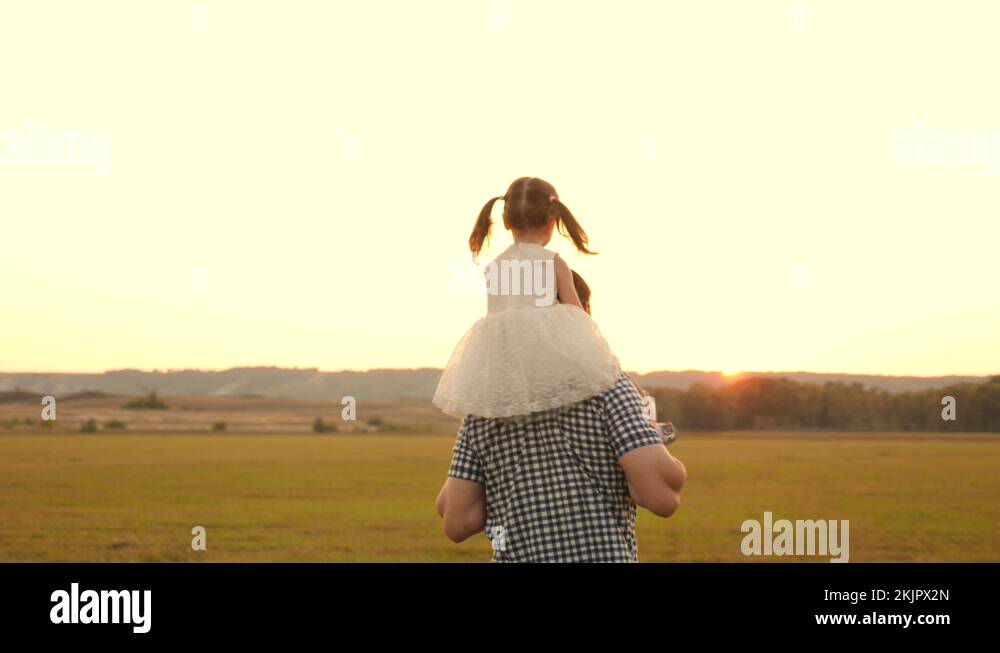 daddy walks with his daughter on his shoulders in rays of sunset. Dad carries on Stock Video ...