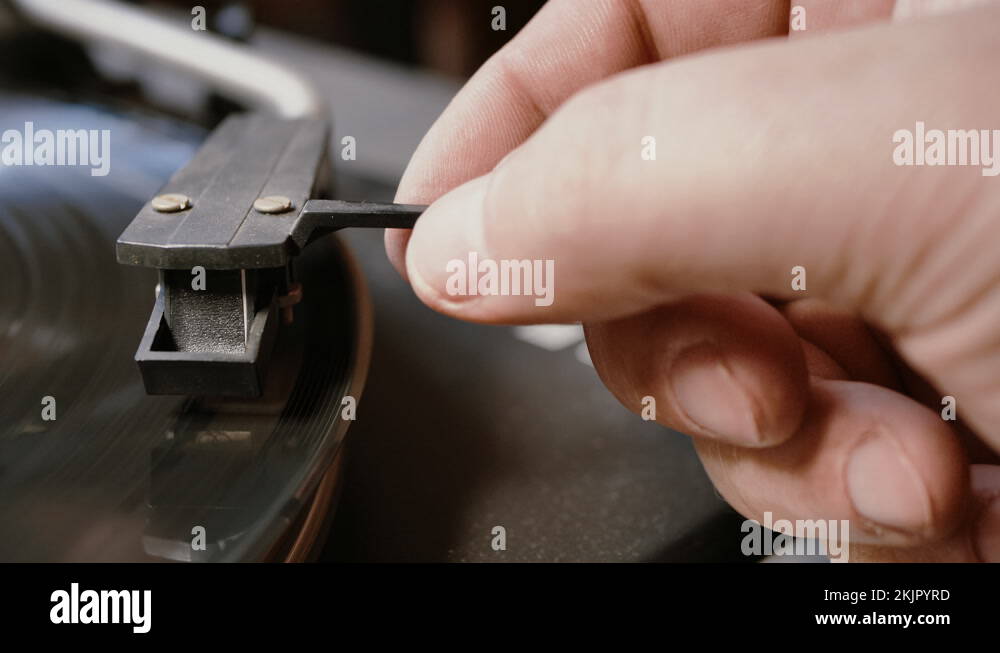 hands placing the vintage turntable on a spinning vinyl record Stock ...
