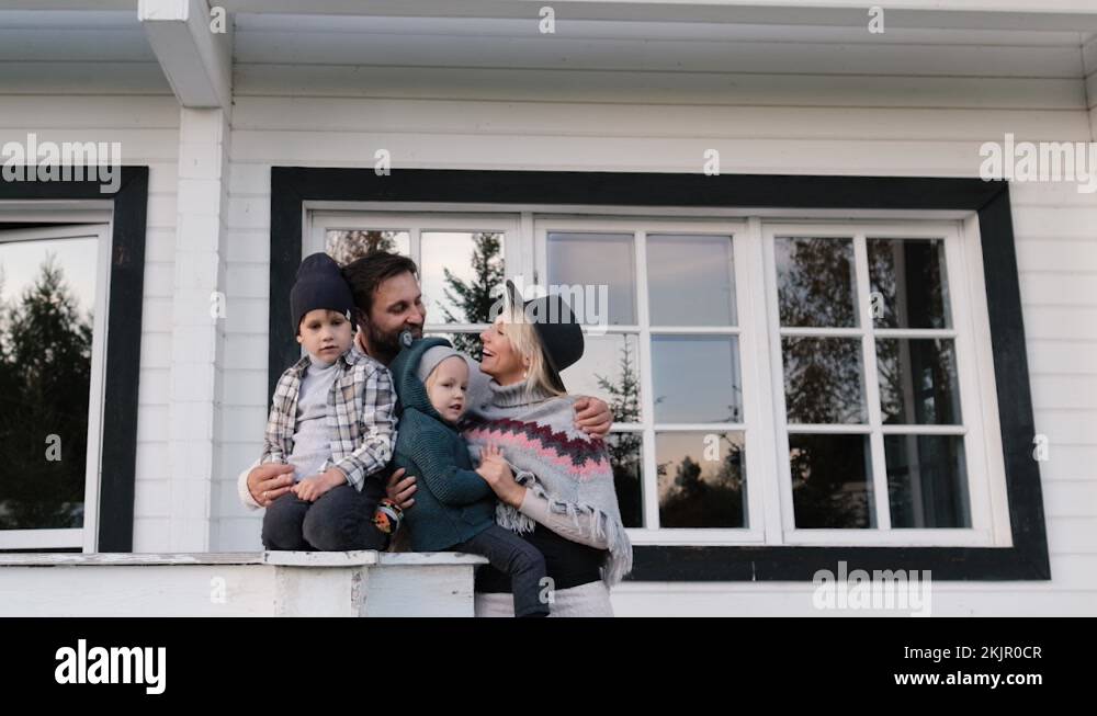 Young happy family with children and big dog having fun on the veranda ...
