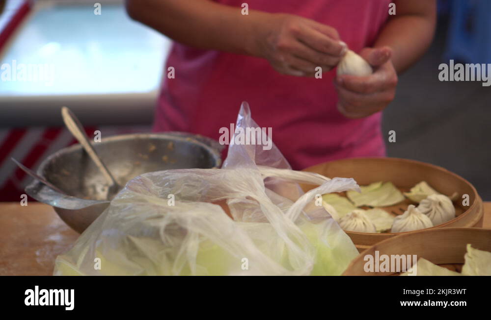 Hand stuffing and closing xiao long boa soup dumplings Chinese dim sum ...