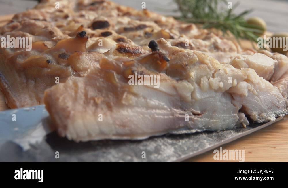The delicious juicy grilled white fish fillet is taken from the wooden ...