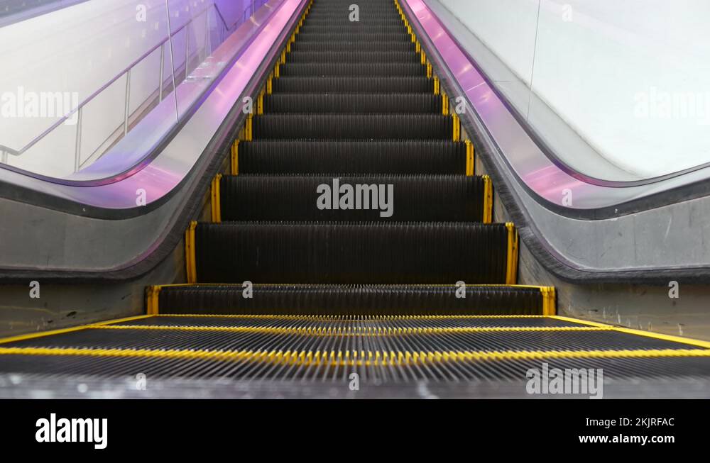 Low angle looped perspective view of modern escalator stairs. Automated ...