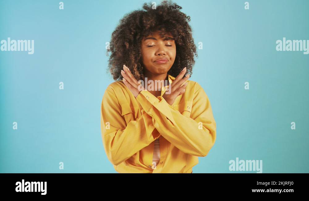 Dark-skinned female showing stop sign by crossed hands, saying no and ...