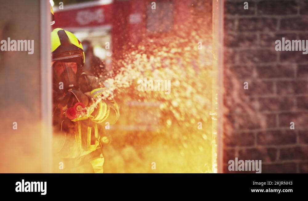 Fireman extinguish fire with the hose. Burning house fire drill Stock ...