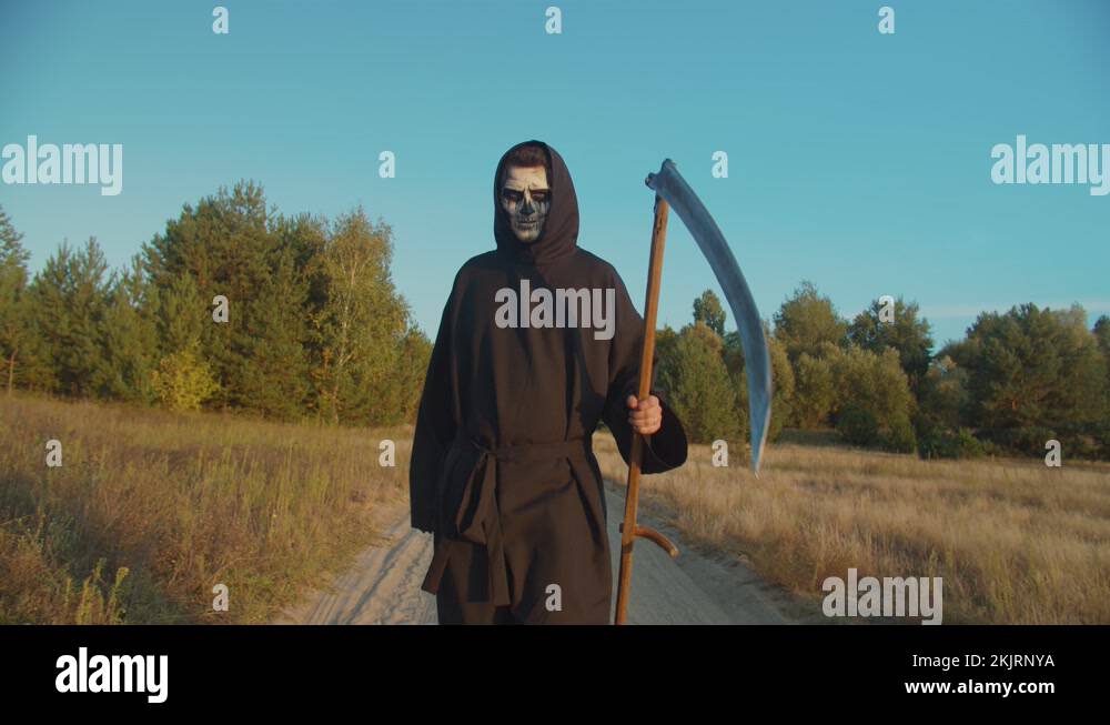 Death reaper frightening with scythe on dirt road Stock Video Footage ...