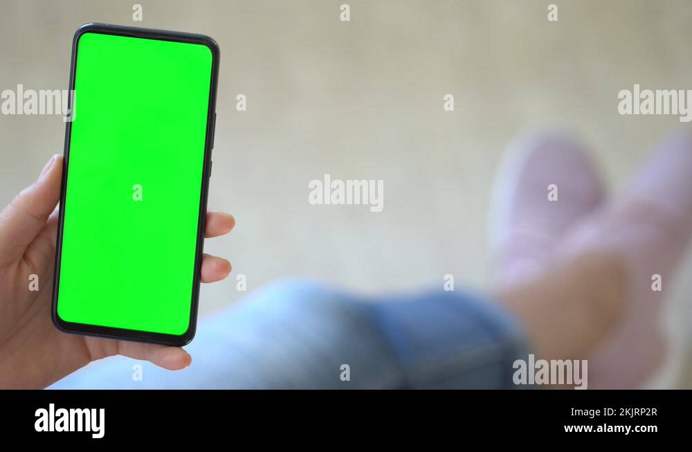 Handheld Camera: Back view of brunette holding chroma key green screen ...