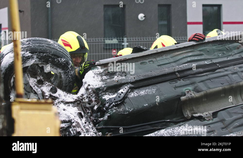 Firefighters turning the wrecked car after extinguished fire Stock ...