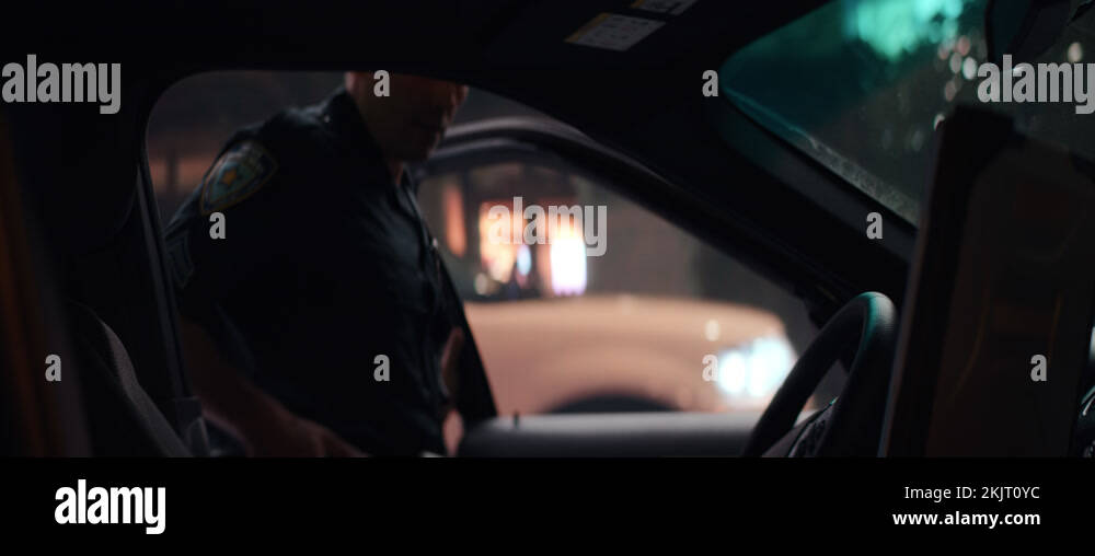 CU Portrait, officer getting inside a police vehicle at night, urban ...