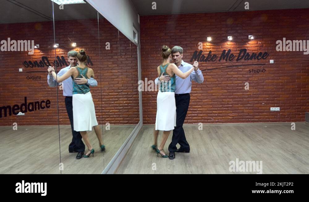 Argentine tango. A man and a woman dance the tango reflected in the ...