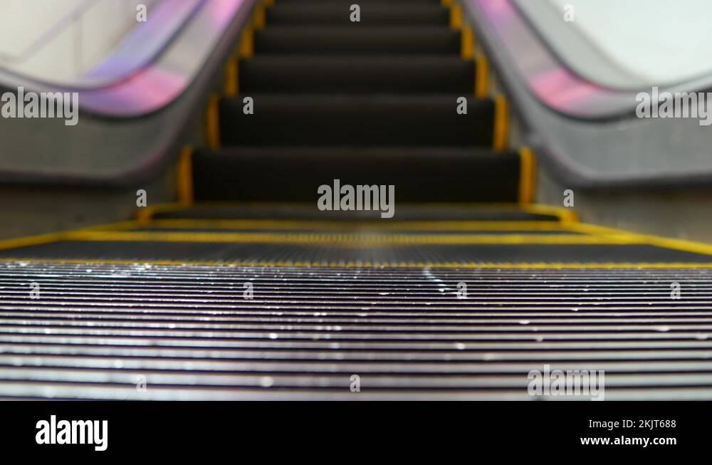 Low angle looped perspective view of modern escalator stairs. Automated ...