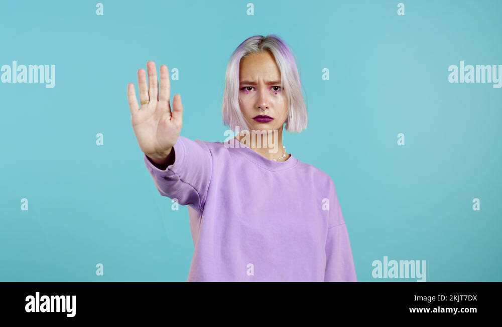 Pretty woman with violet hair disapproving with NO hand sign gesture ...