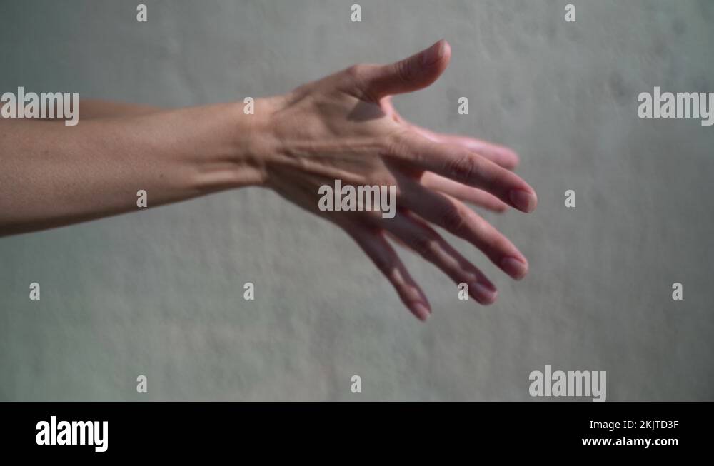 female hands turn the open palms in different directions, then connect ...