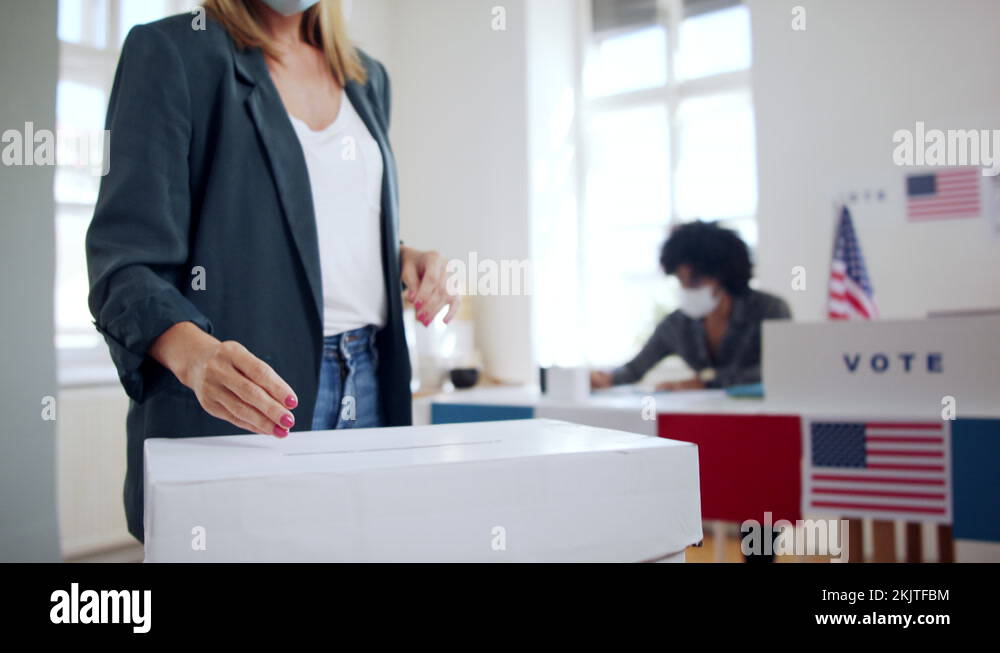 Young woman putting her vote in the ballot box, usa elections and ...