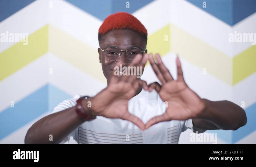Young flirty African-American man making hand gesture expressing love ...