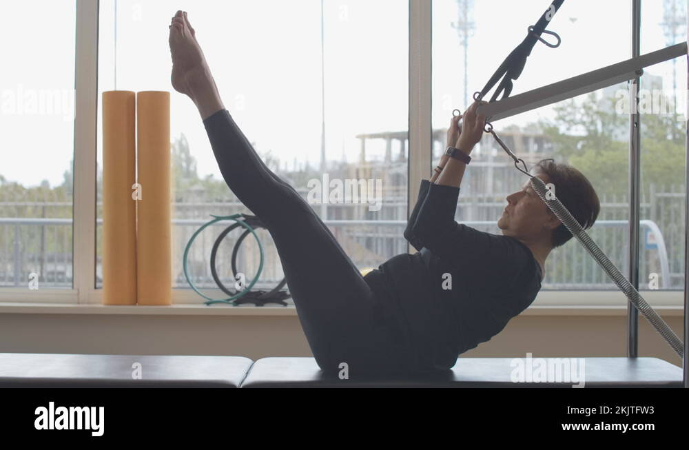 Caucasian retiree doing leg scissors exercise and lying down on bench ...