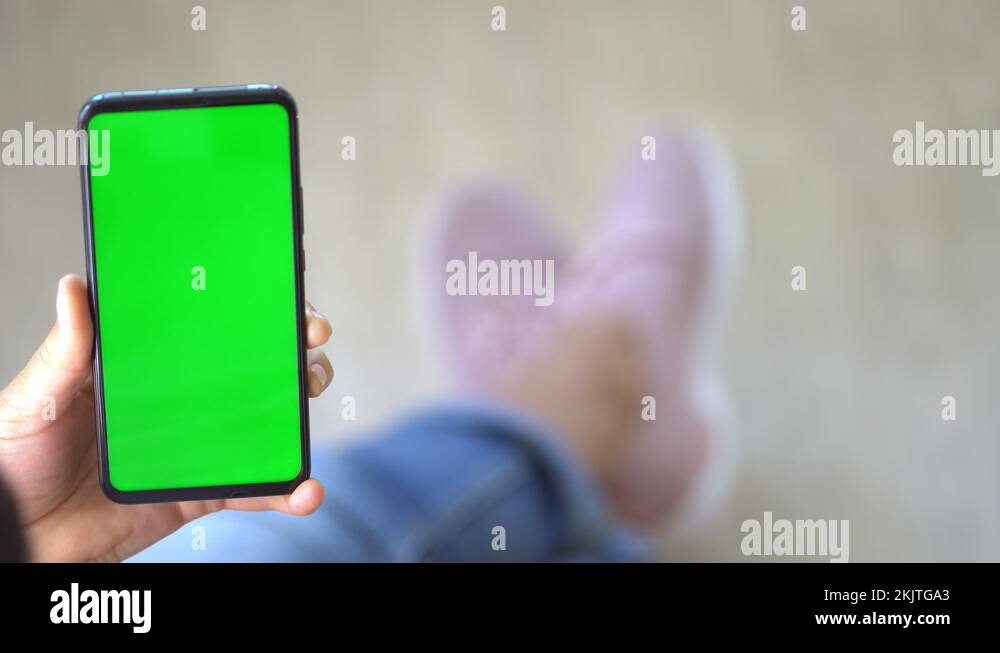 Handheld Camera: Back view of brunette holding chroma key green screen ...