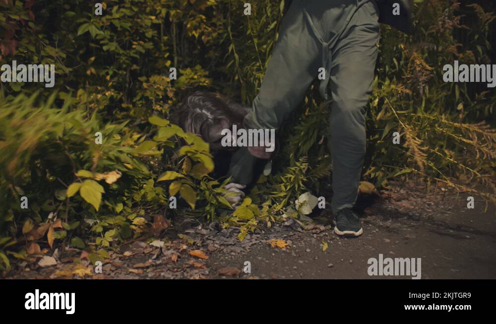 Woman talking on walkie-talkie when zombie crawling out of bushes and ...