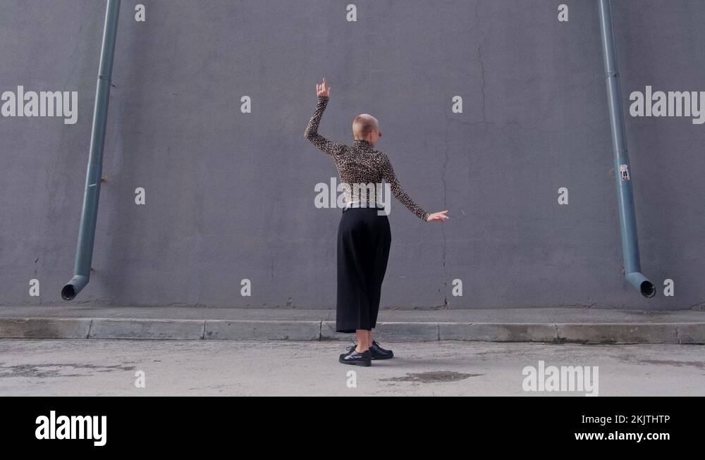 Woman with short hair in a leopard turtleneck and glasses dancing ...