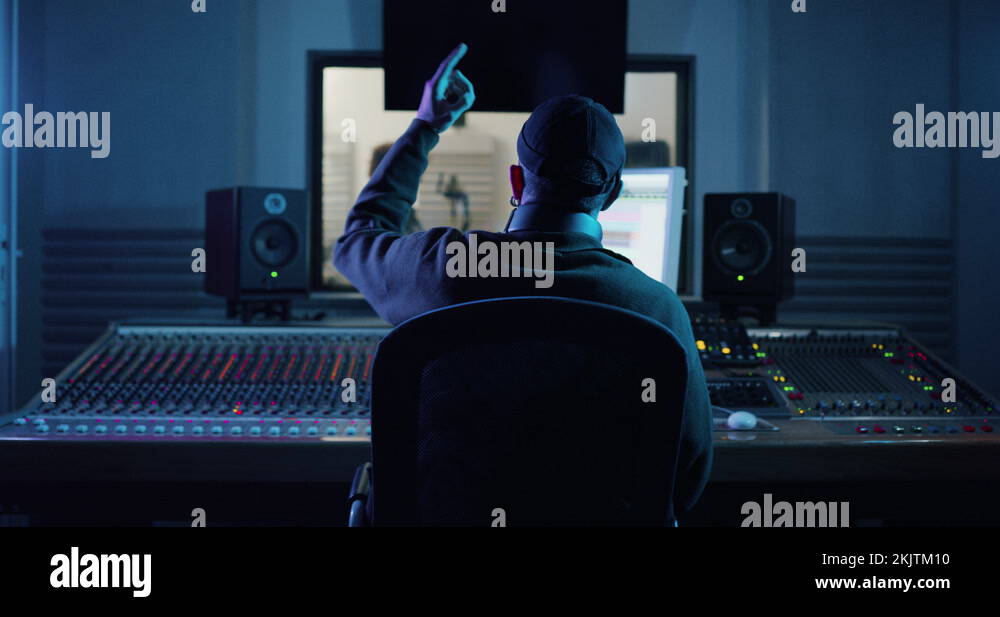 Back view of producer recording song with african female singer in ...