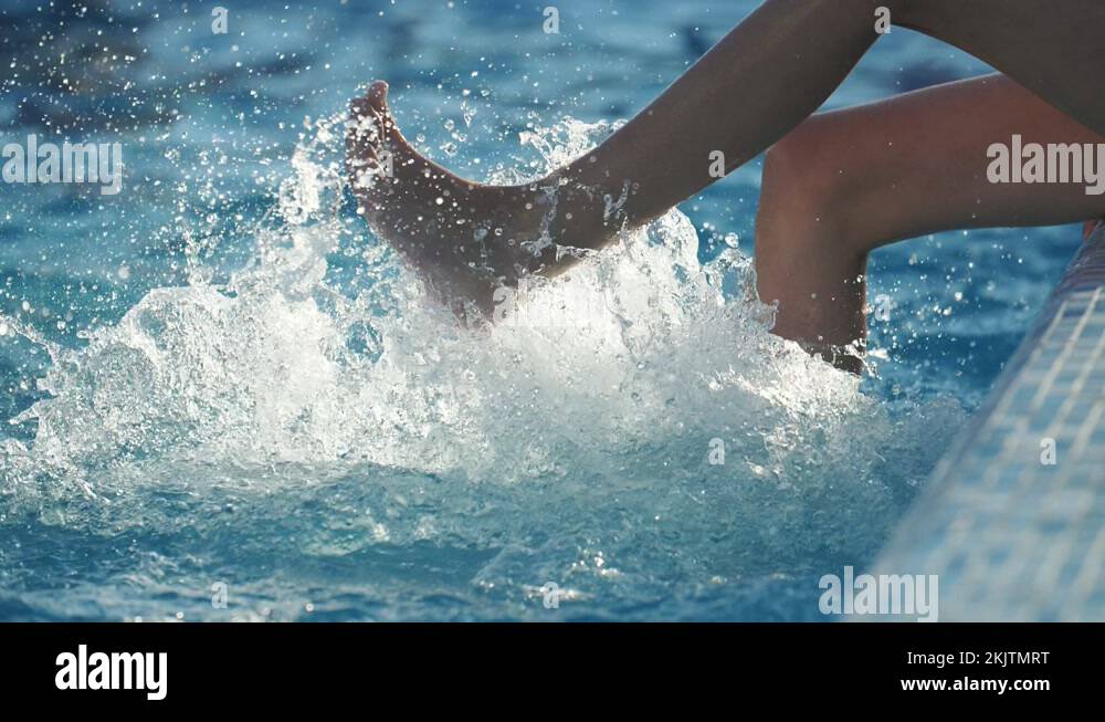 Zappy boy`s legs doing bike movements beat water in a wading pool in ...
