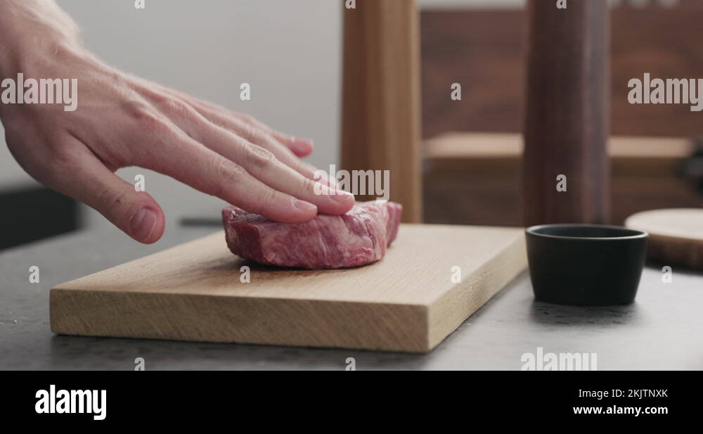 Man hand put raw ribeye steak on oak wood board Stock Video Footage - Alamy