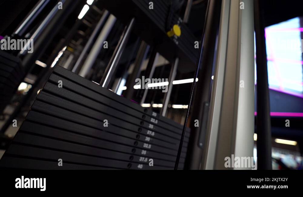 lifting and lowering weight of sporty simulator in gym, closeup view ...