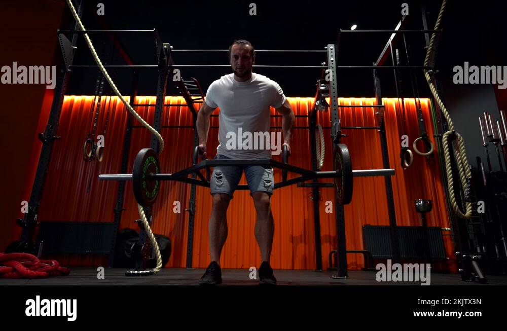powerlifter is lifting rod with weights in gym, strongman and ...