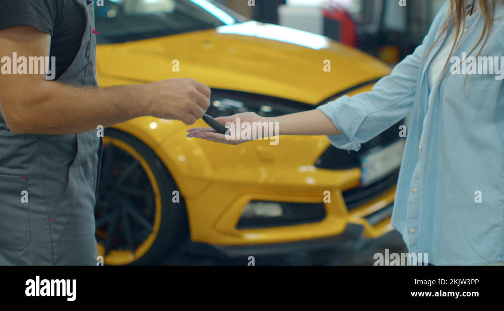 Mechanic gives the customer the keys to his repaired car. Modern clean ...