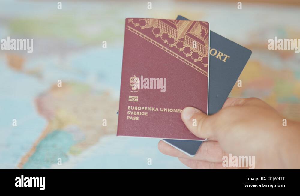Hand Holding A Swedish And American Passports In Front Of A Colorful