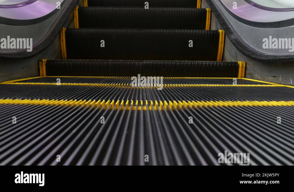 Low angle looped perspective view of modern escalator stairs. Automated ...