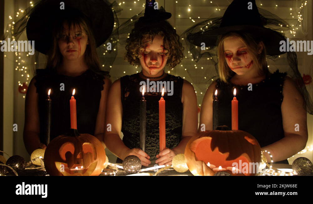 Three teenage girls in witch costumes with frightening akeup on their ...