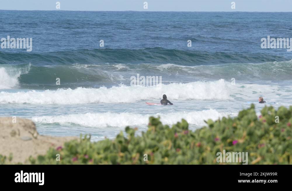 Surfers in ocean, pacific coast sea water waves. People surfing with ...