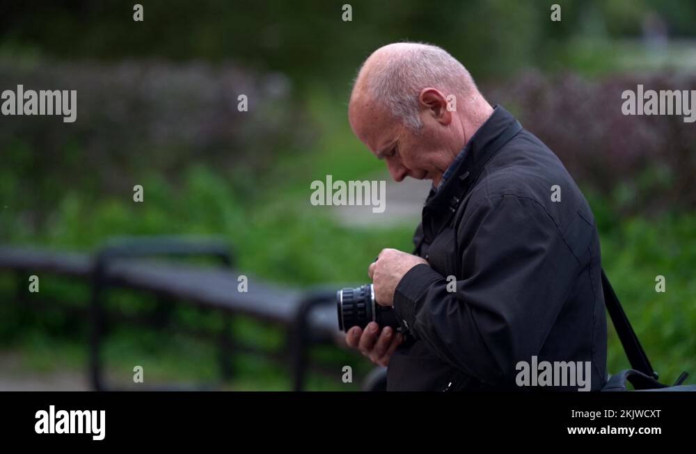 An elderly bald man in nature, blurred green background of the Park and ...