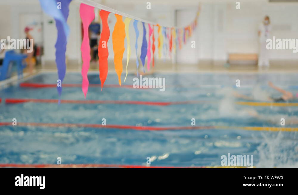 swimmers teenagers start in the pool and swim along the lanes ...