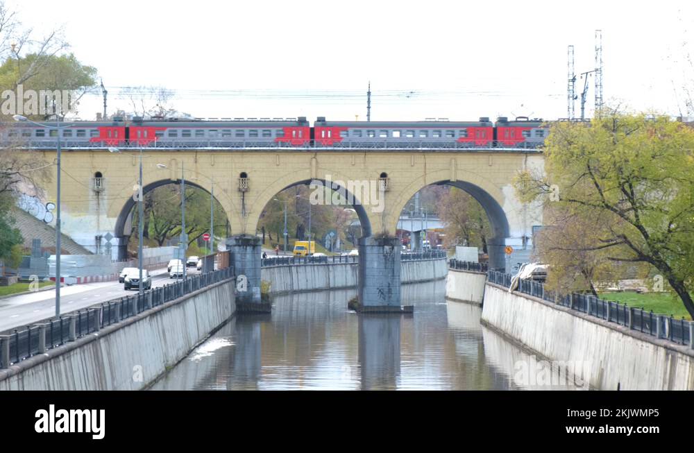 Suburban train rides across the railway bridge within the city Stock ...