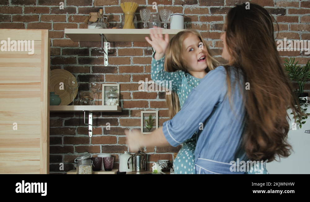 Happy mom dancing with her little daughter. Mom and daughter are ...