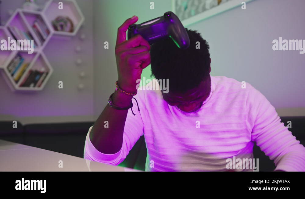 Black man playing game using console controlling joystick ...