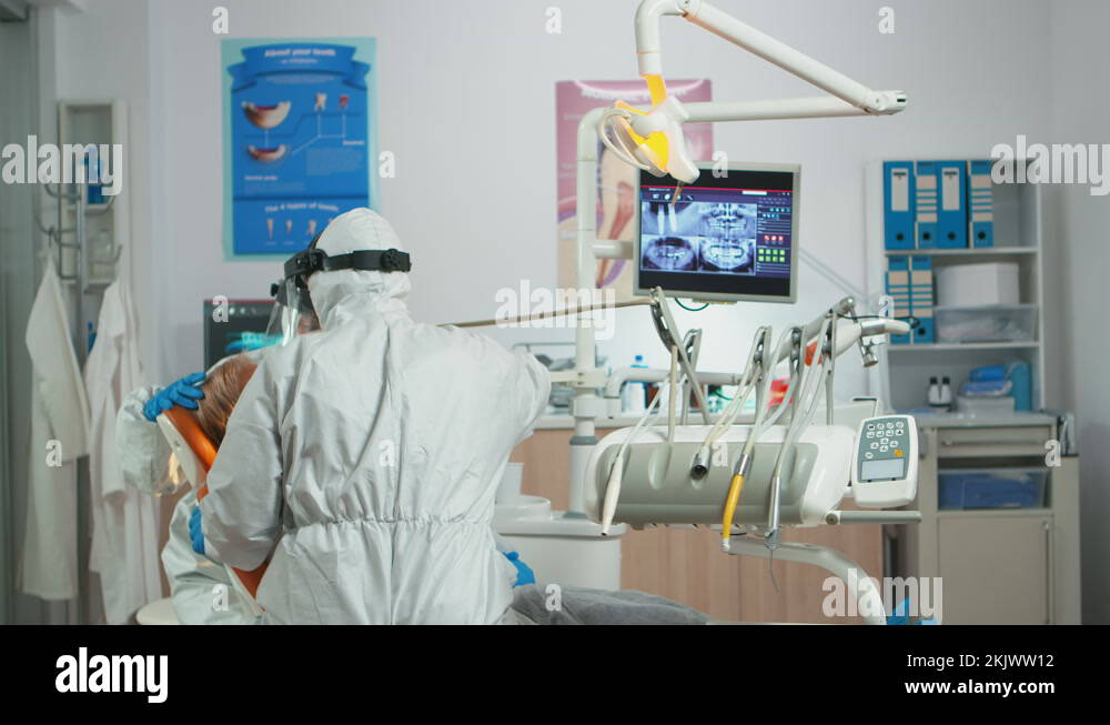 Dentist with face shield working in dental unit during covid-19 Stock ...