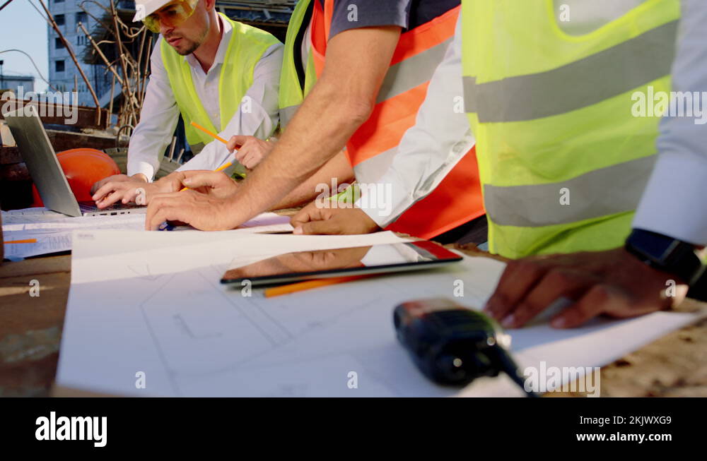 Closeup details group of architects and engineers check the plan of the ...