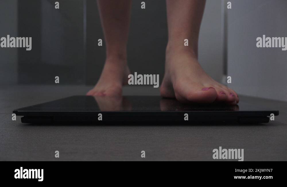 Woman measuring her weight on a weighing scale Stock Videos & Footage ...
