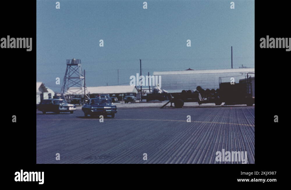 1960s Vietnam: Cars driving by military base. View of ground. Cars ...