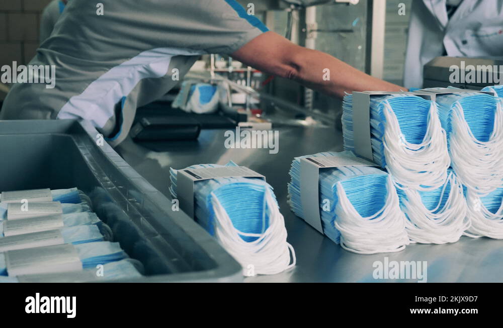 Batches of face masks are getting relocated onto the conveyor belt ...